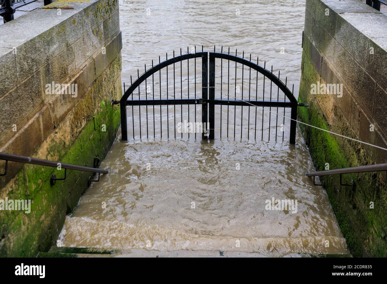 High tide on the River Thames in London, flooded gate and steps to the ...