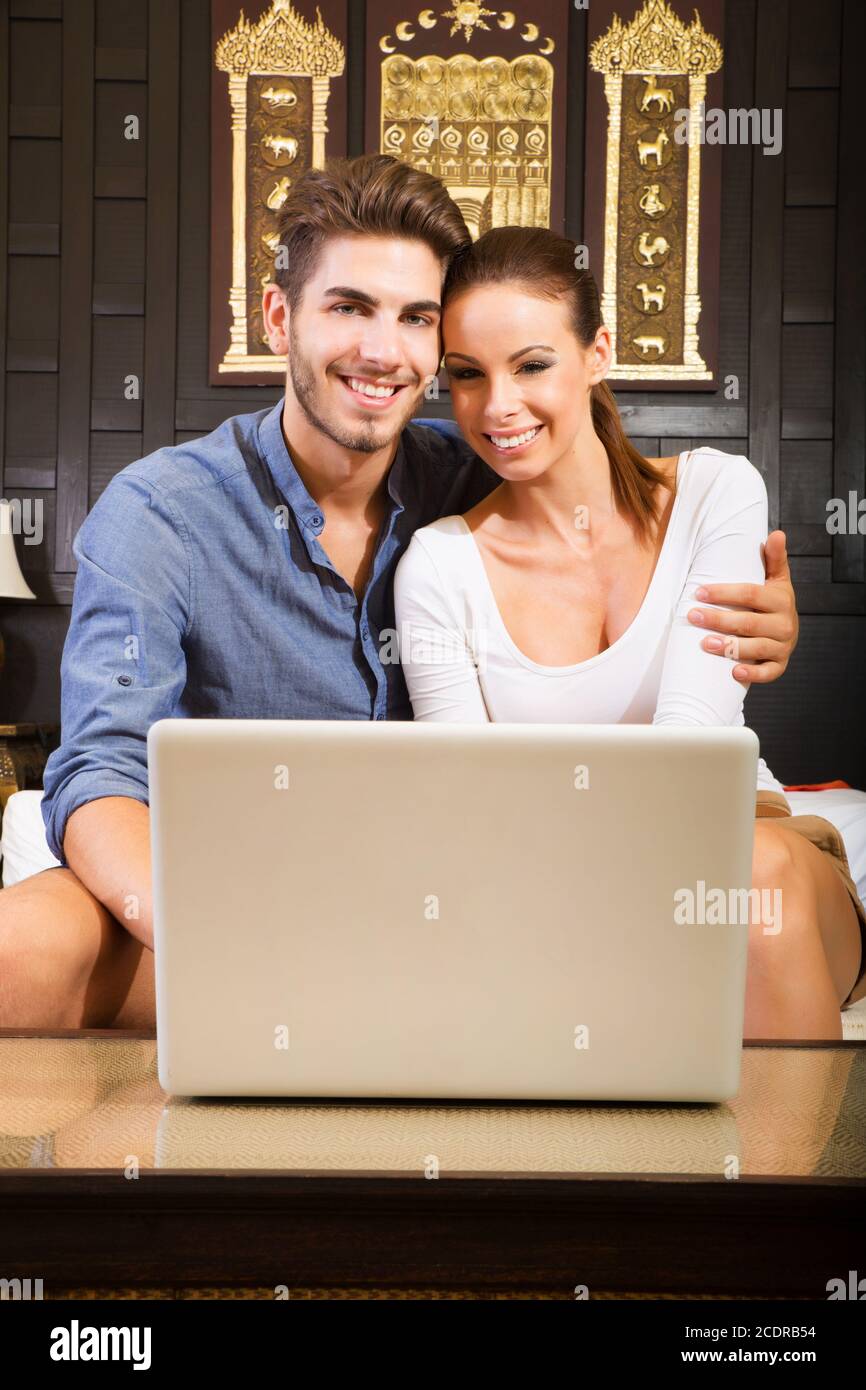 Young couple using a laptop computer in a asian hotel room Stock Photo ...