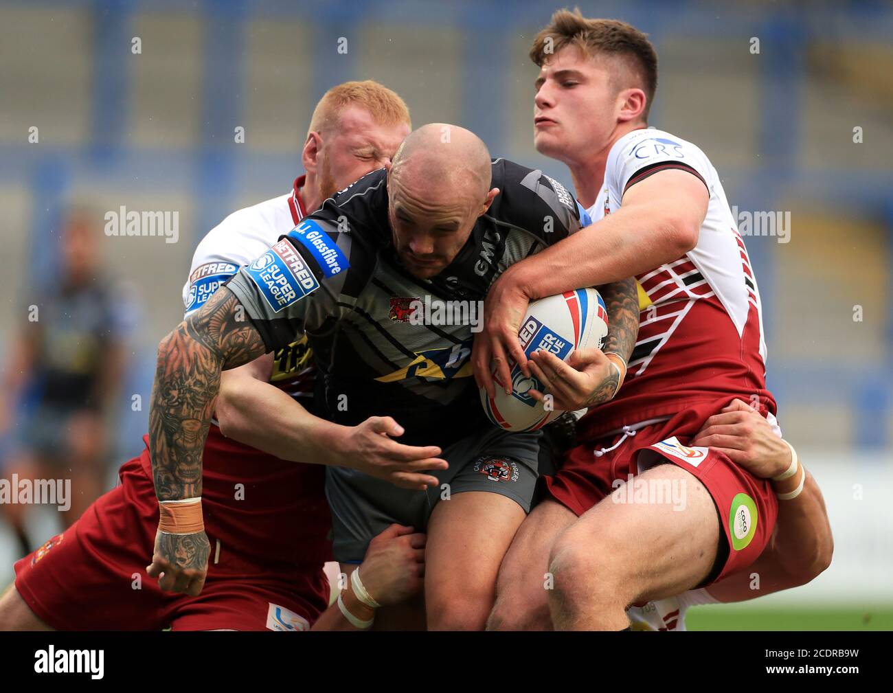 Castleford Tigers' Nathan Massey (centre) is tackled by Wigan Warriors ...