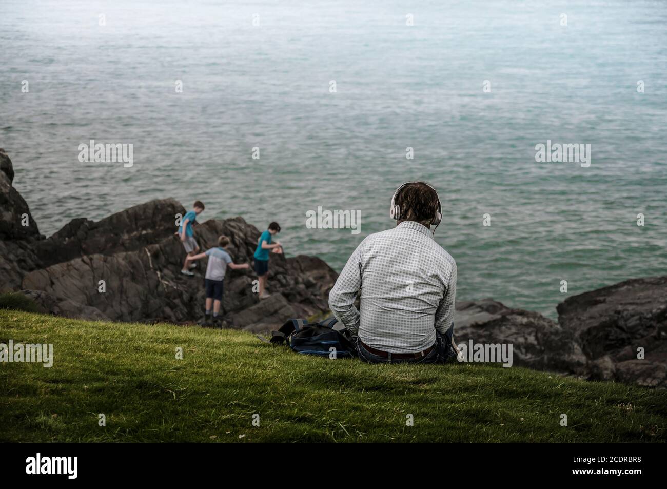 Visiting Greystones. Man with headphones relaxing in front of the sea ...