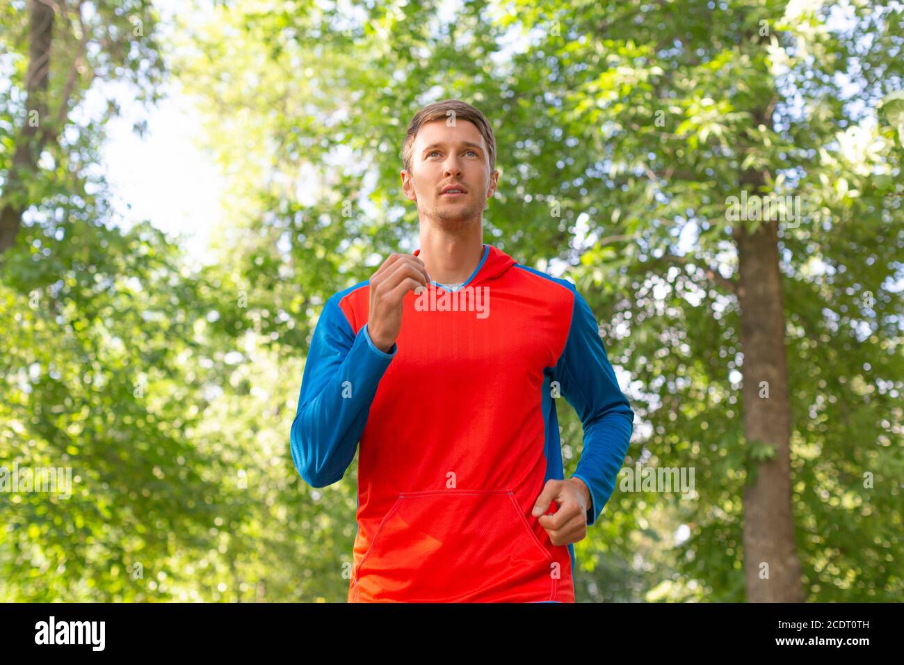 Sportsman runs along the road in the forest. Close up portrait. The ...