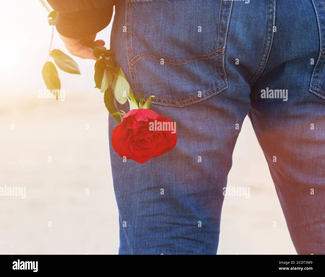 Man with a rose behind his back waiting for love. Romantic date on the ...