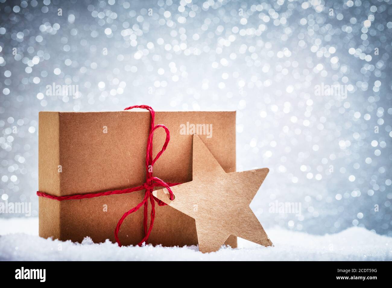 Retro rustic Christmas gift, present in snow on glitter background ...