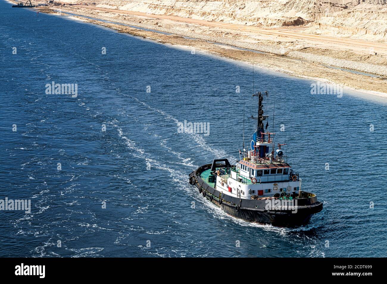 Tugboat runs in the new extension section of the Suez Canal Stock Photo ...
