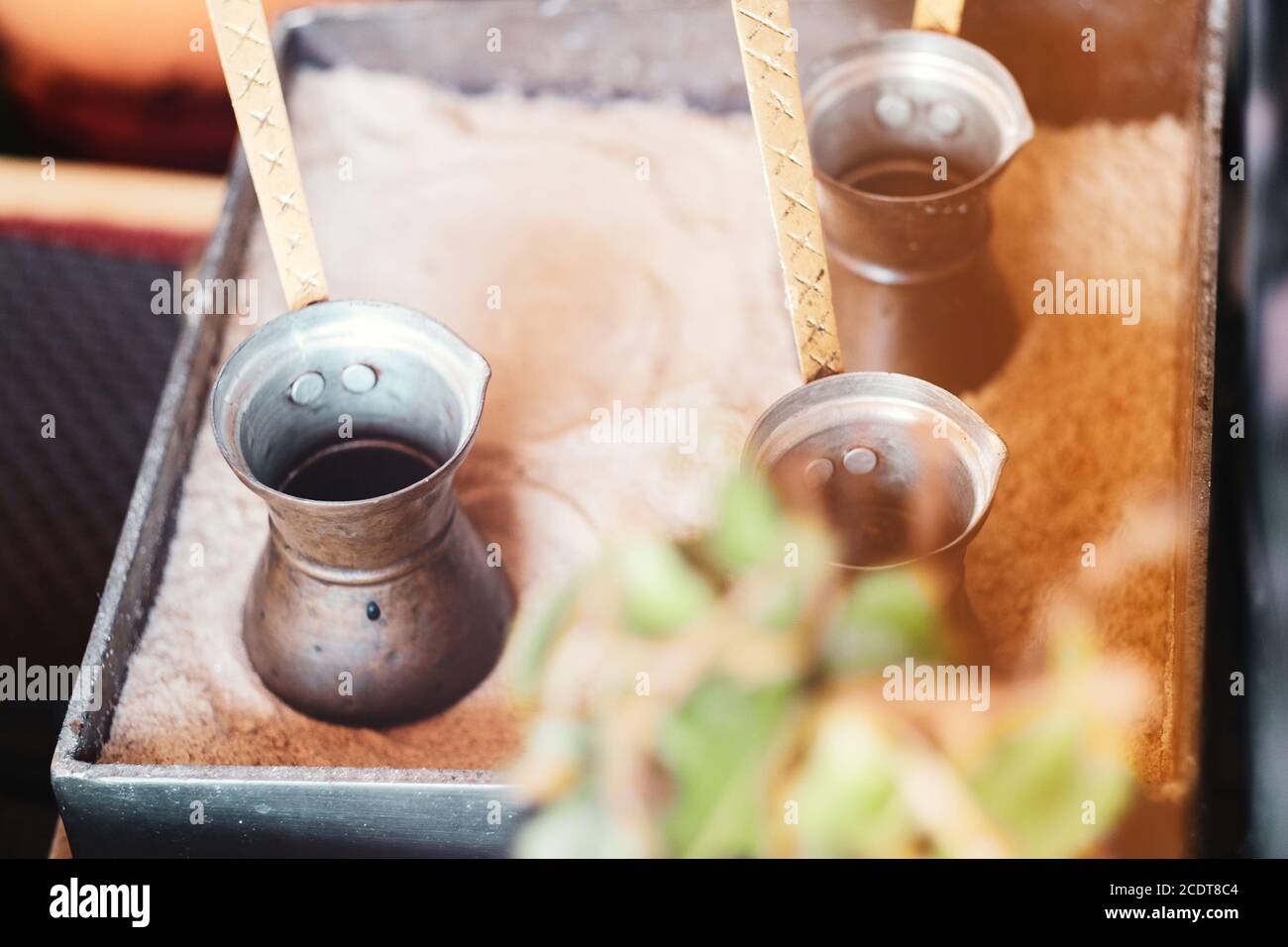 Preparation of Turkish coffee in the cezve in the sand at the cafe bar ...