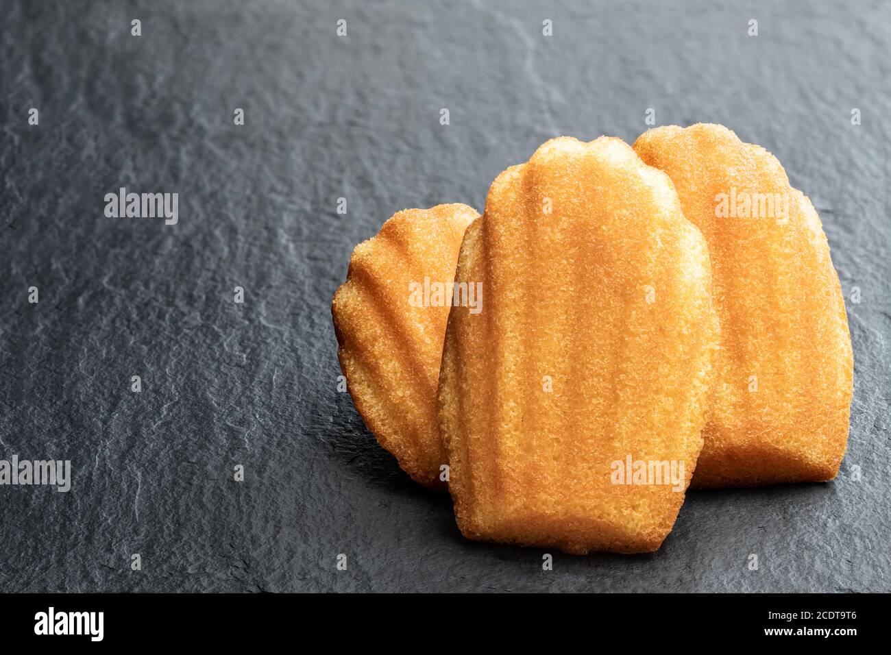 Homemade madeleines french sponge cake on black stone background Stock ...