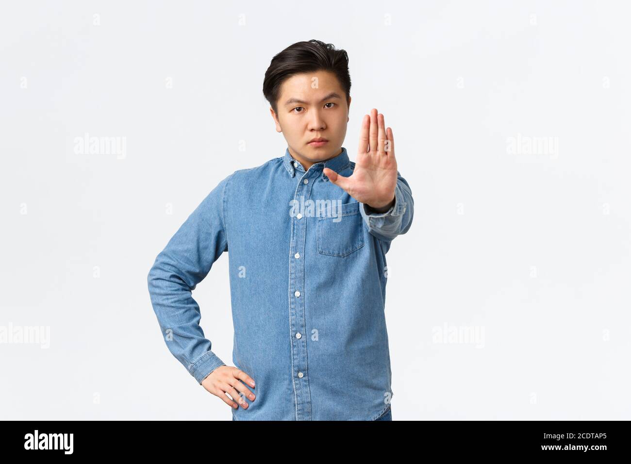 Serious strict asian man extending hand to shop stop gesture, scolding ...