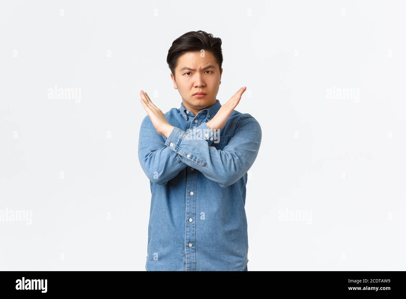 Serious-looking concerned asian male student showing forbid gesture ...