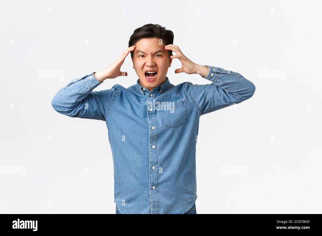 Mad and distressed asian man looking furious and frustrated, losing ...