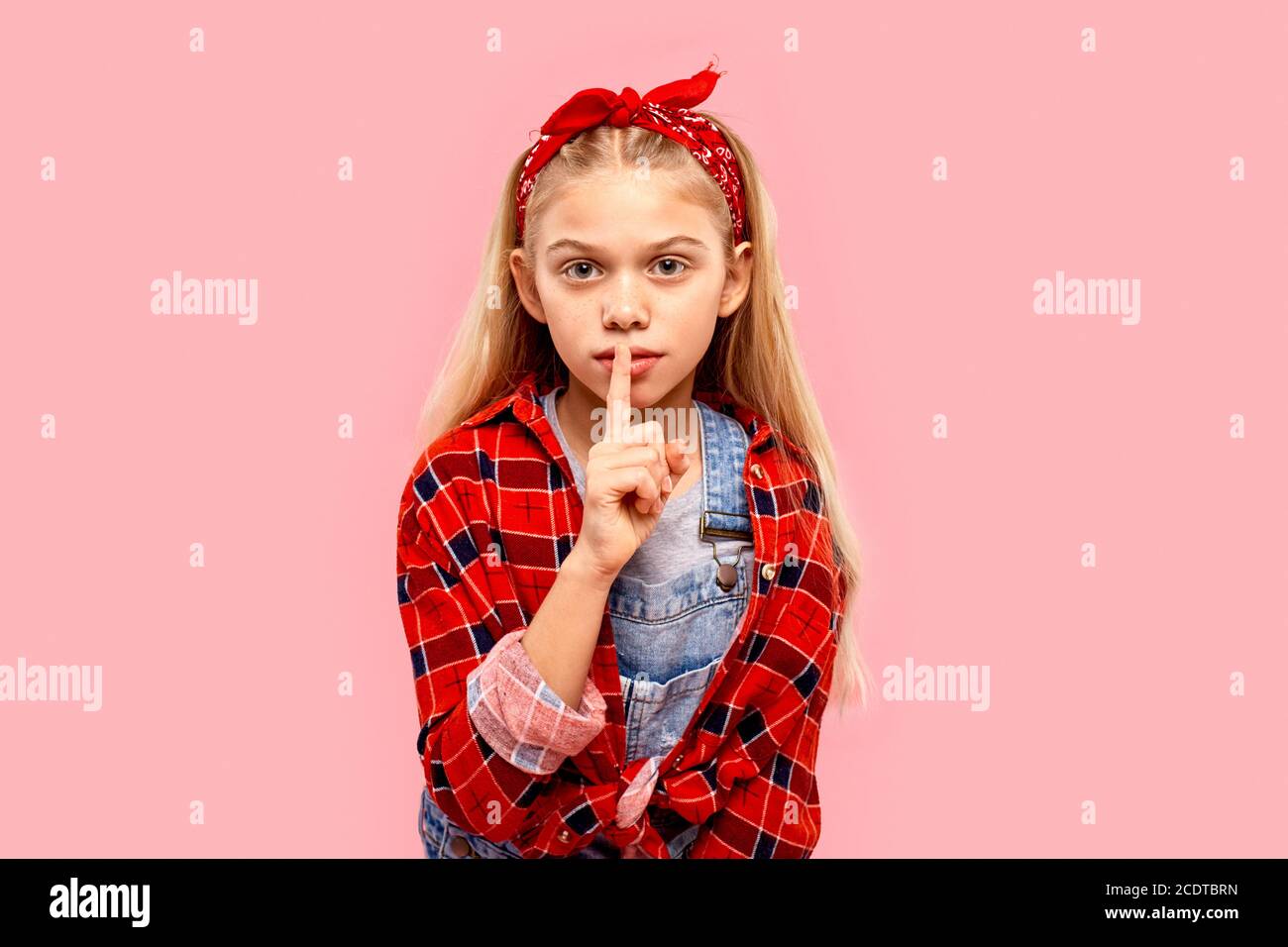 Child girl looking at camera, making shh sign Stock Photo - Alamy