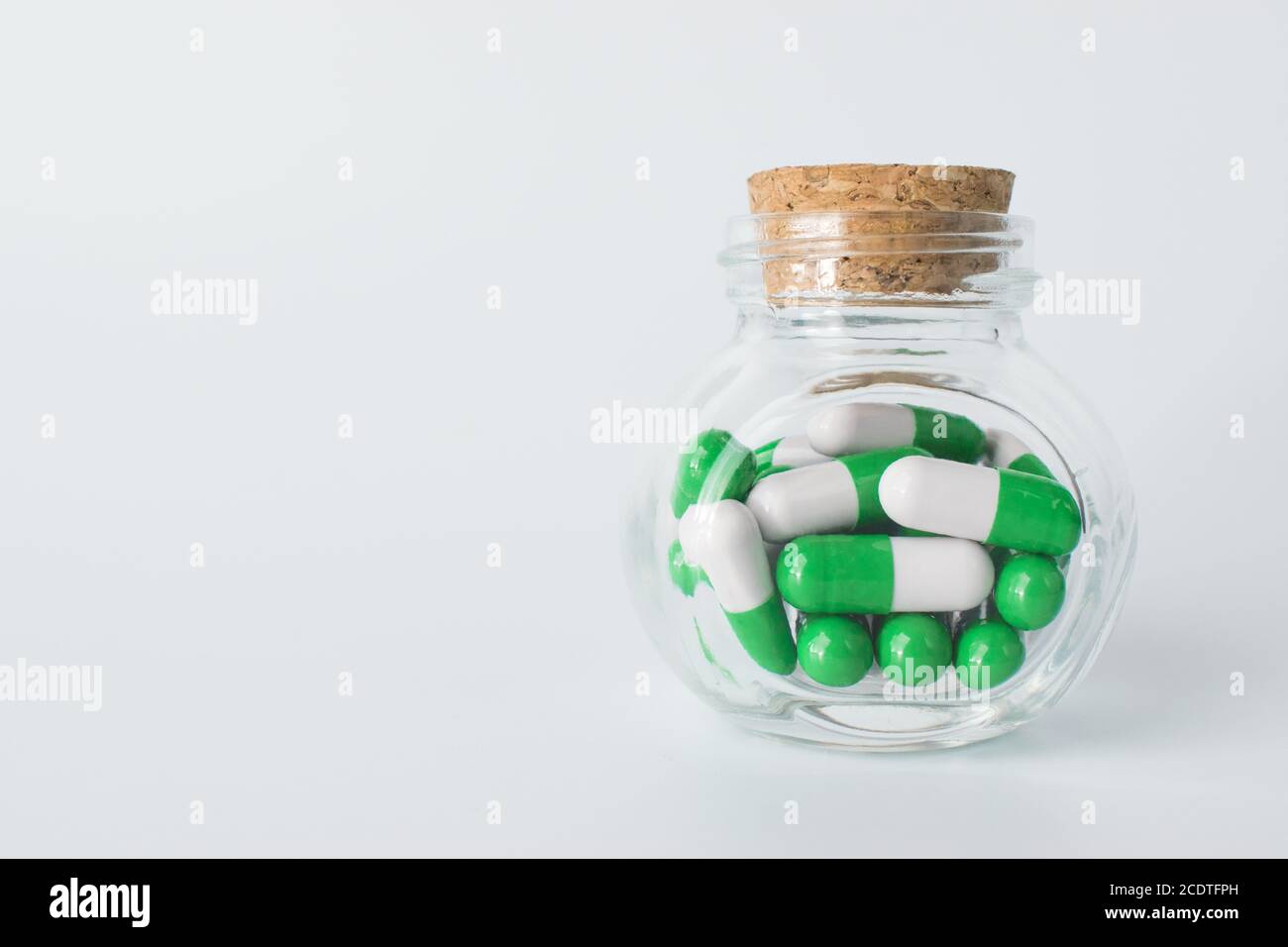 Glass container with capsules on a white background with a copy space ...