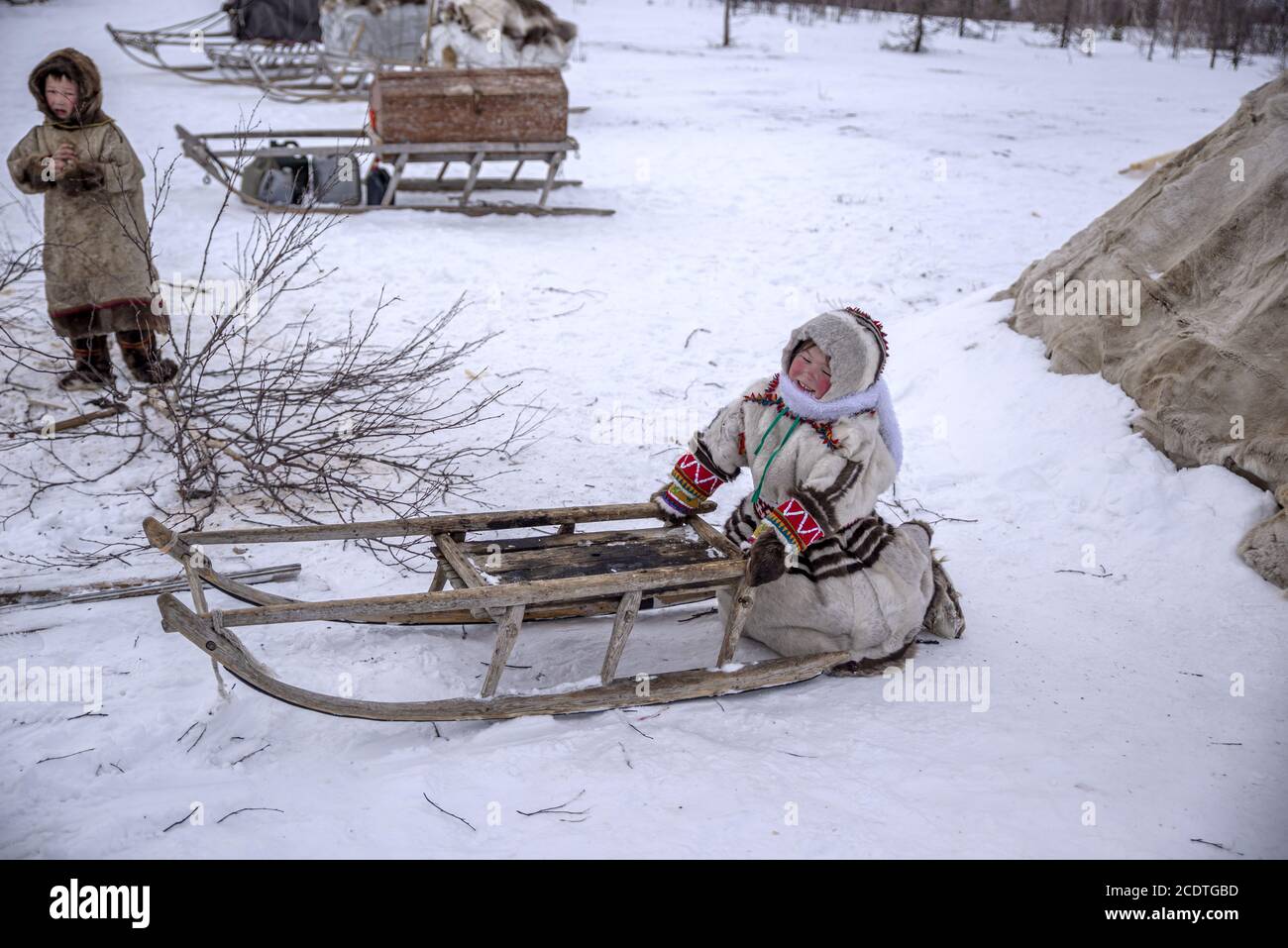 A young Nenet girl playing with a traditional wooden sled, Yamalo ...