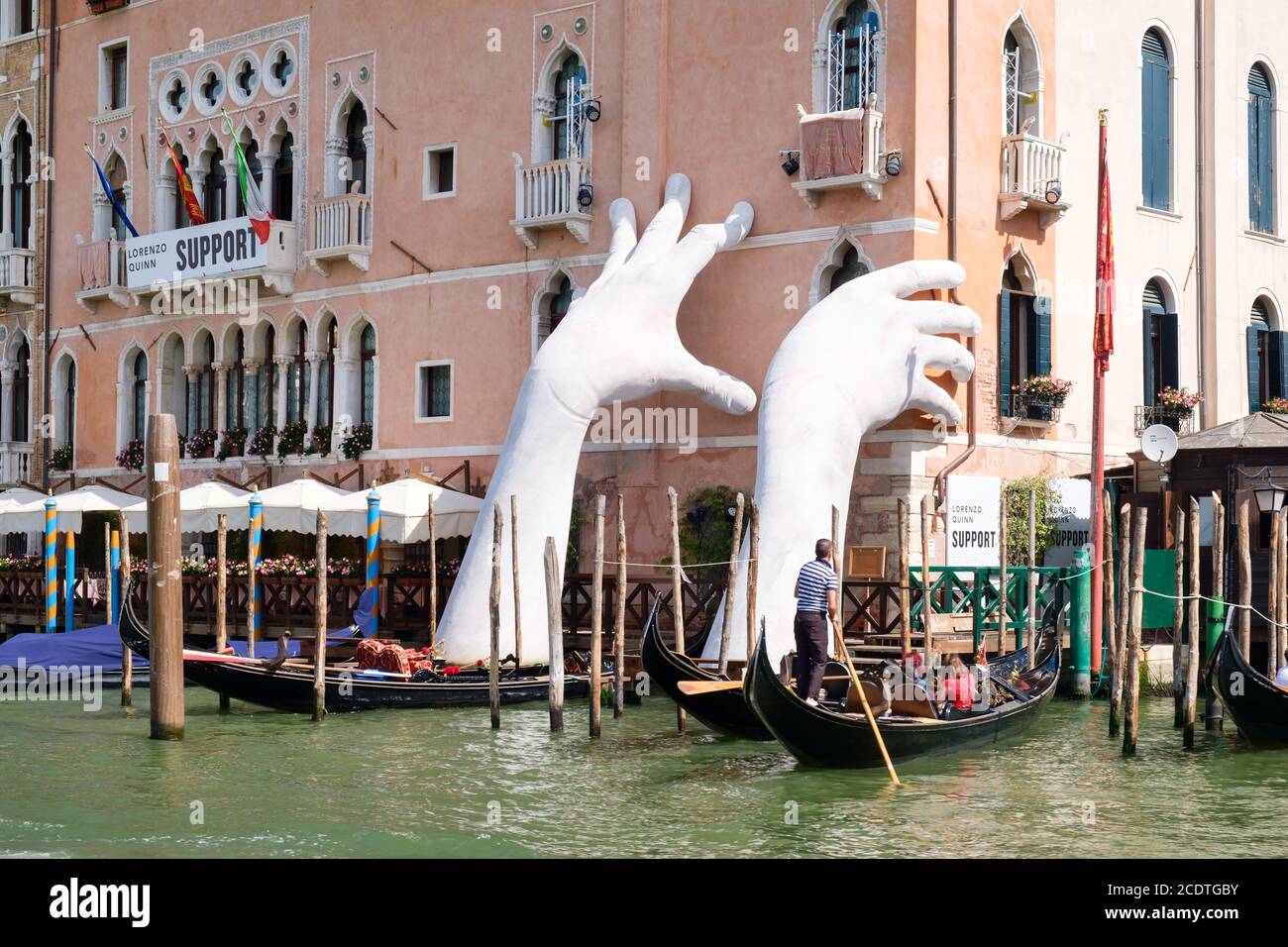 VENICE,ITALY - JULY 26,2017 : Giant hands supporting an old palace next ...