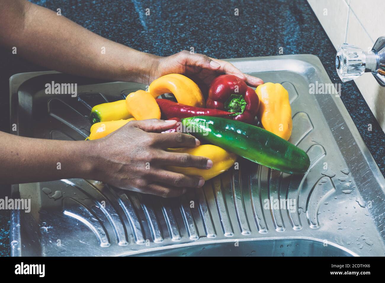 Lady ready to wash red and yellow bell peppers and fresh paprika Stock ...