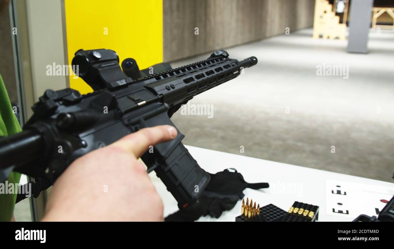Adult loading an assault rifle at a shooting range Stock Photo - Alamy
