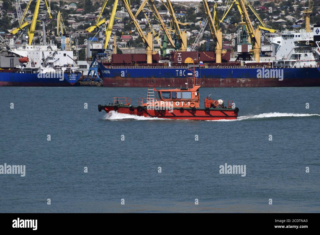 Small ship in the port of the service. Red small boat. Cargo port with ...