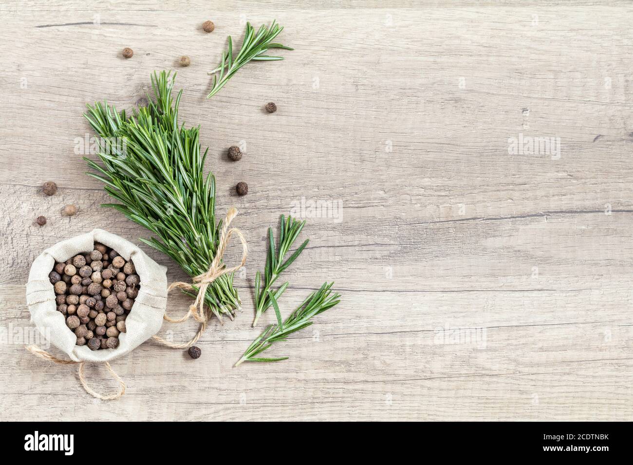 Rosemary and fragrant pepper on light wooden surface Stock Photo - Alamy