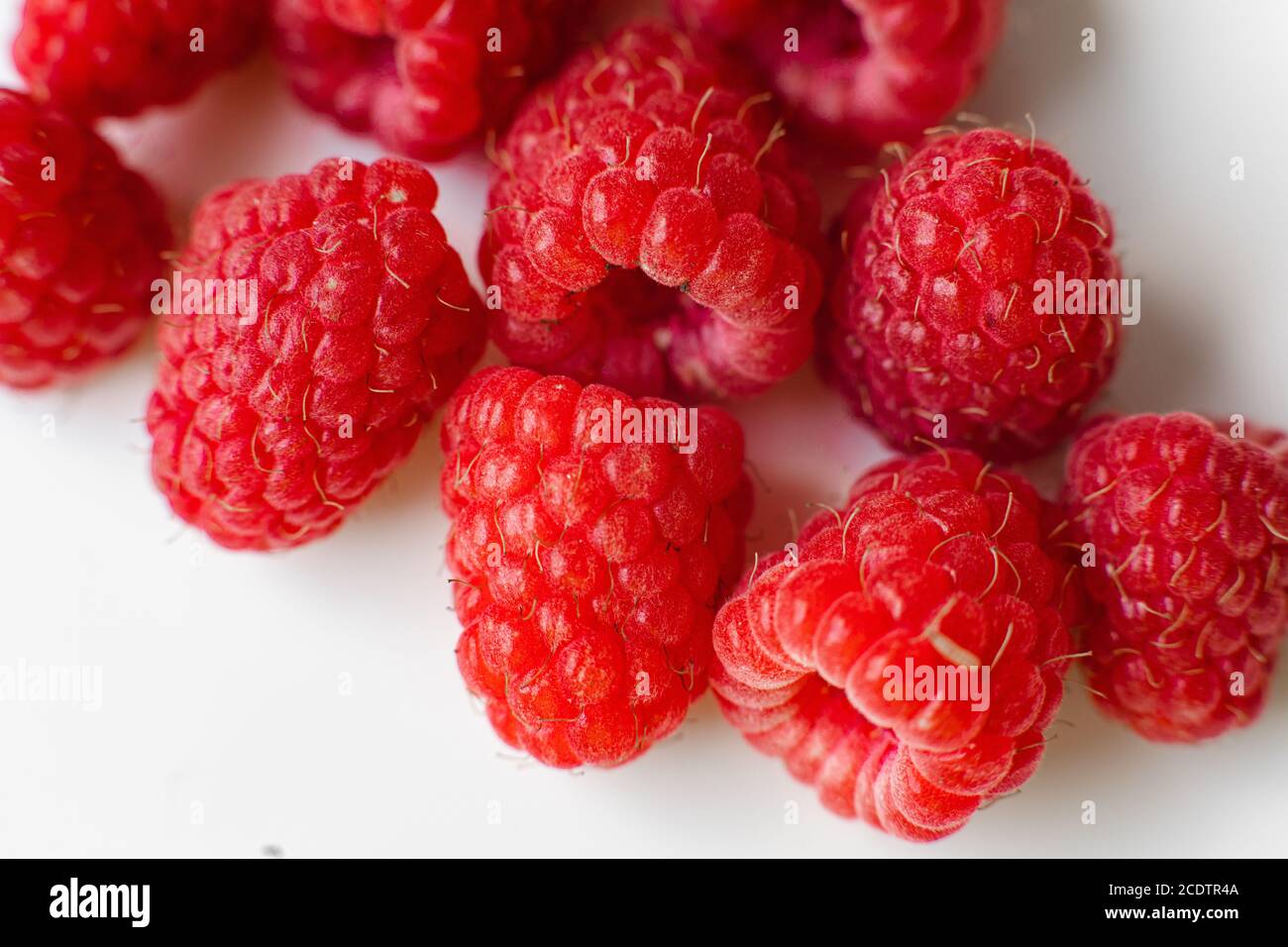 A picture of a few raspberries lies on a white background. Background ...