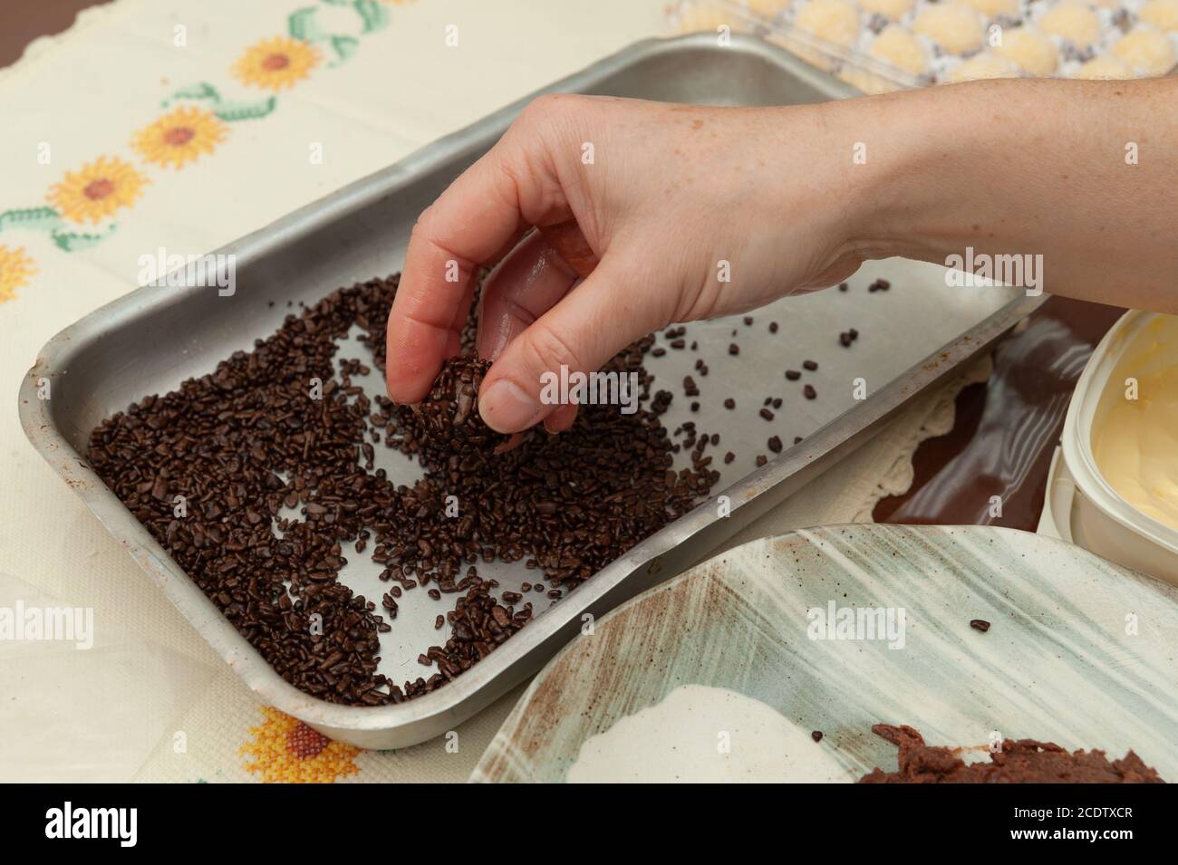 Close-up of woman hands making delicious and traditional Brigadeiros ...