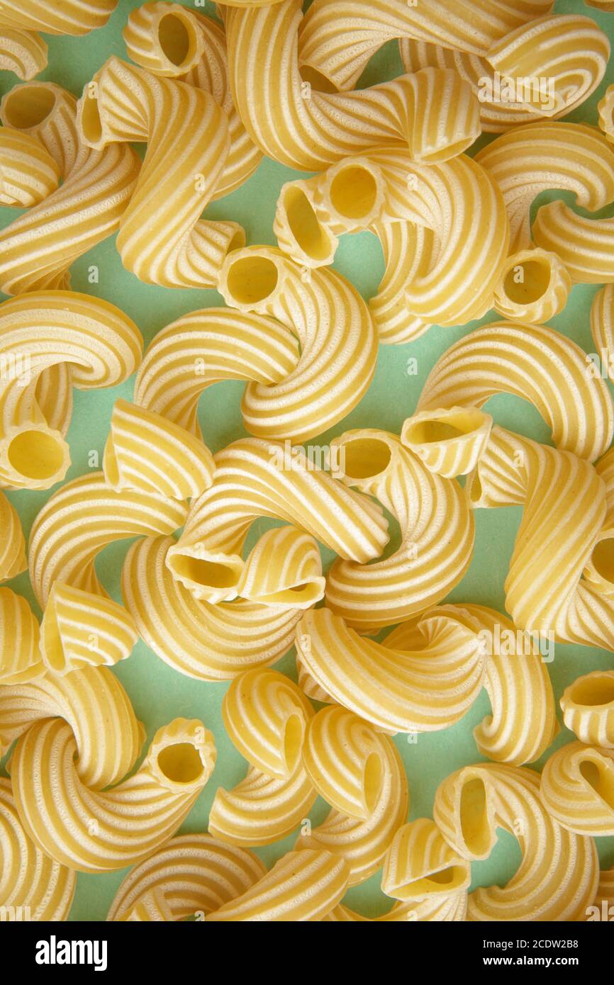 background of pasta in the form of tubes spun in a spiral Stock Photo ...