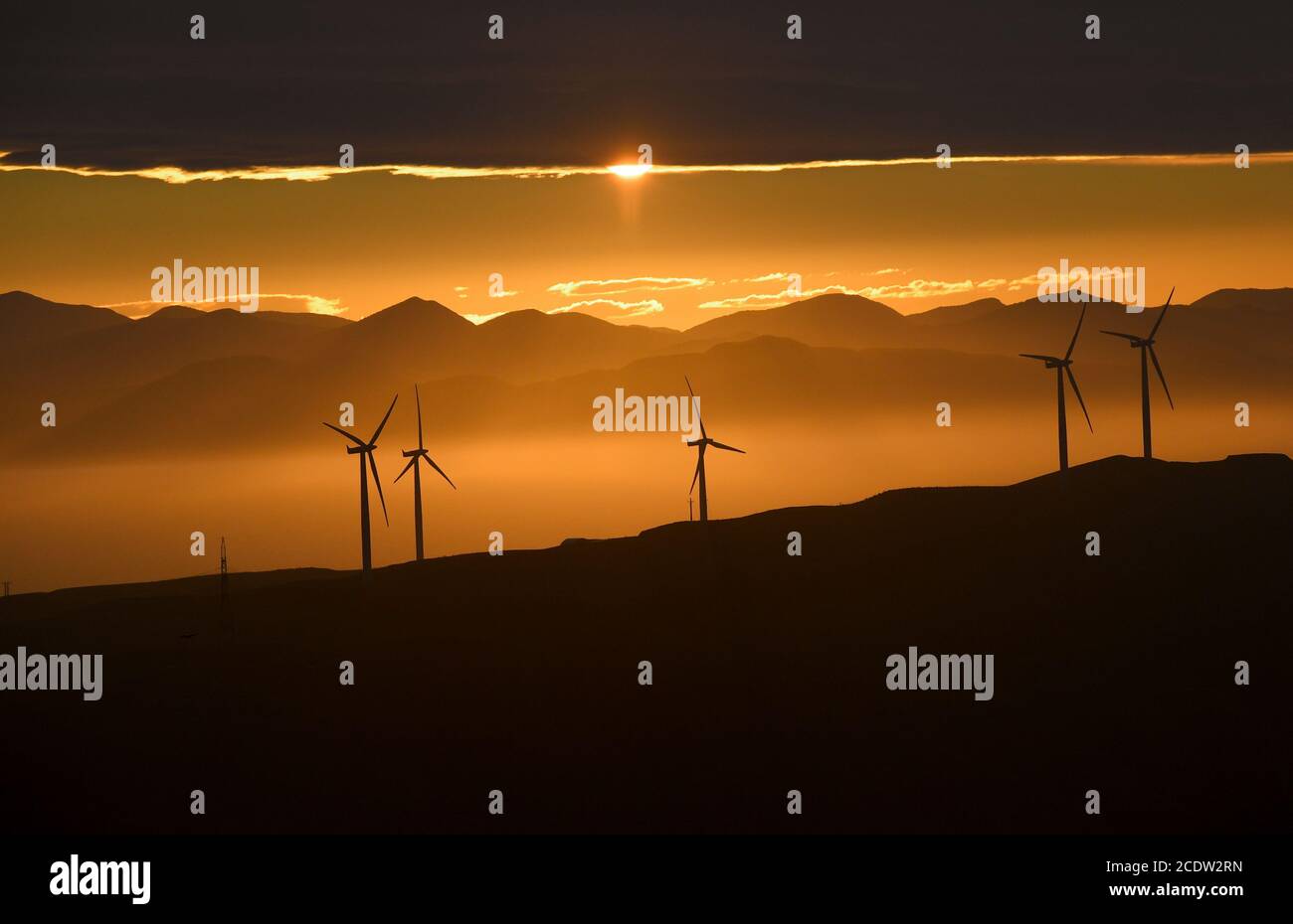 Wellington, New Zealand. 25th Apr, 2020. Wind turbines stand in sunset ...