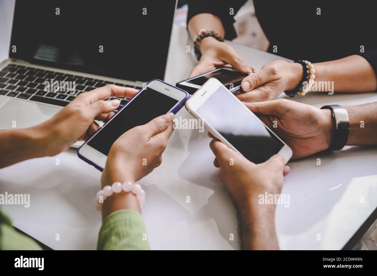 Group of young hipsters holding mobile phones in hands at office with ...