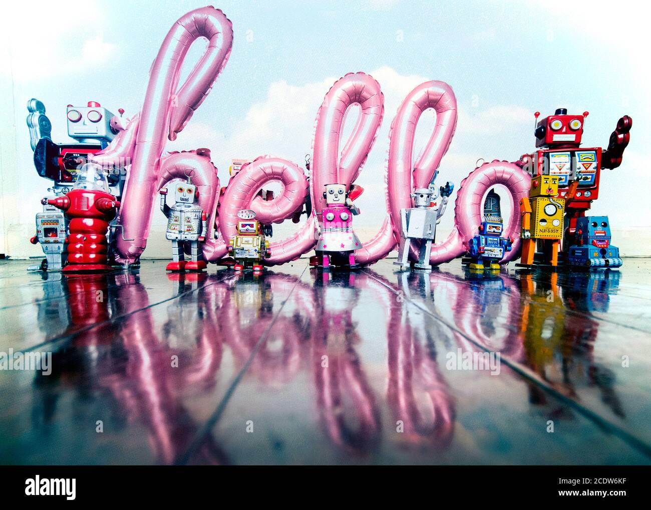 robots holding up the word hello on a old wooden floor with reflection ...