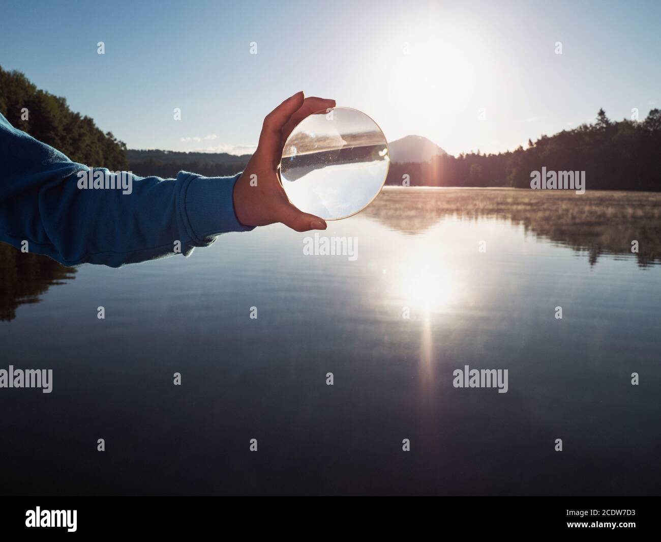 Children hand hold lens. World reflection in the glass ball with sun ...