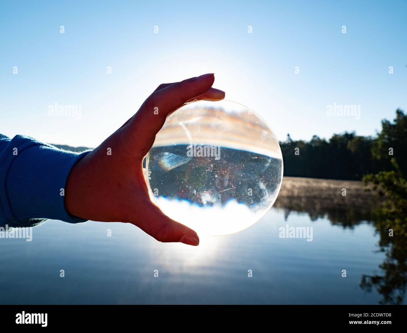 Children hand hold lens. World reflection in the glass ball with sun ...