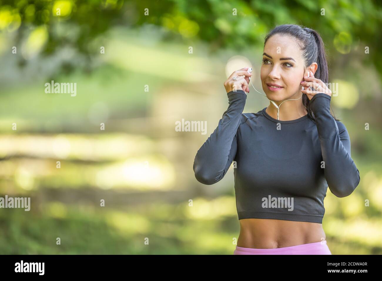 Young sporty woman runner with a nice smile before running with ...