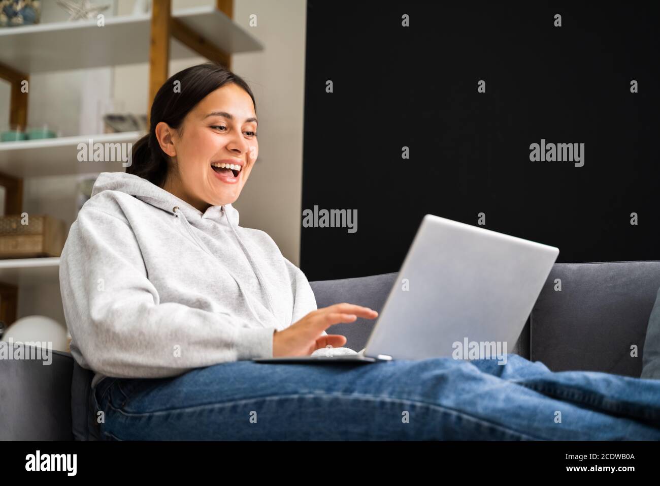Women Using Computer Laptop On Couch Or Sofa Stock Photo - Alamy