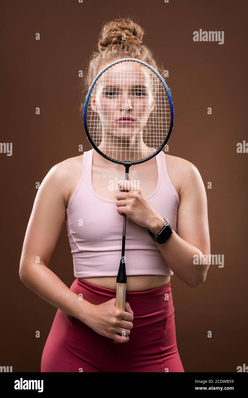Young female tennis player holding racket in front of her face in ...
