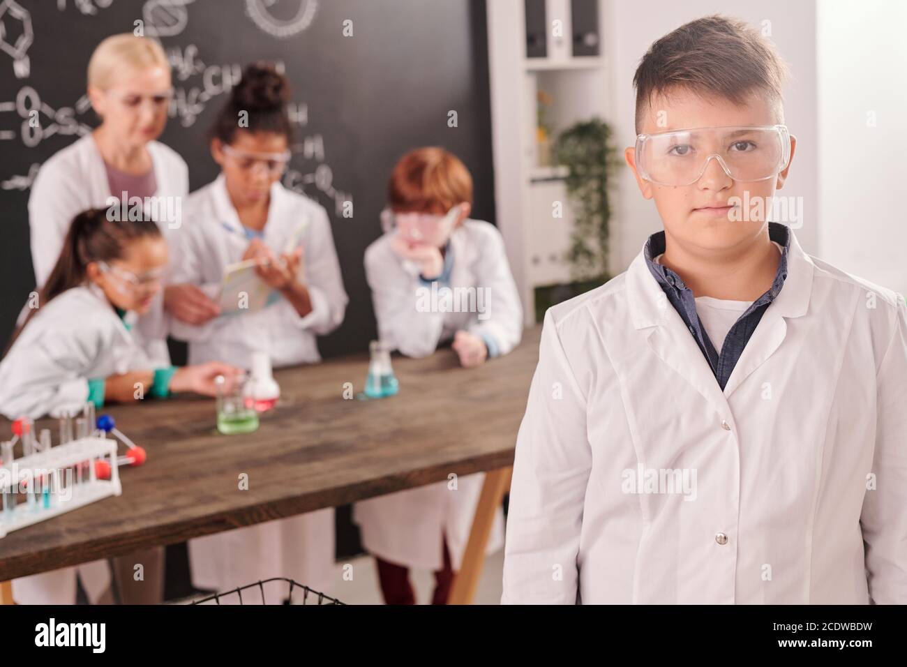 Contemporary pupil of secondary school in whitecoat and protective ...