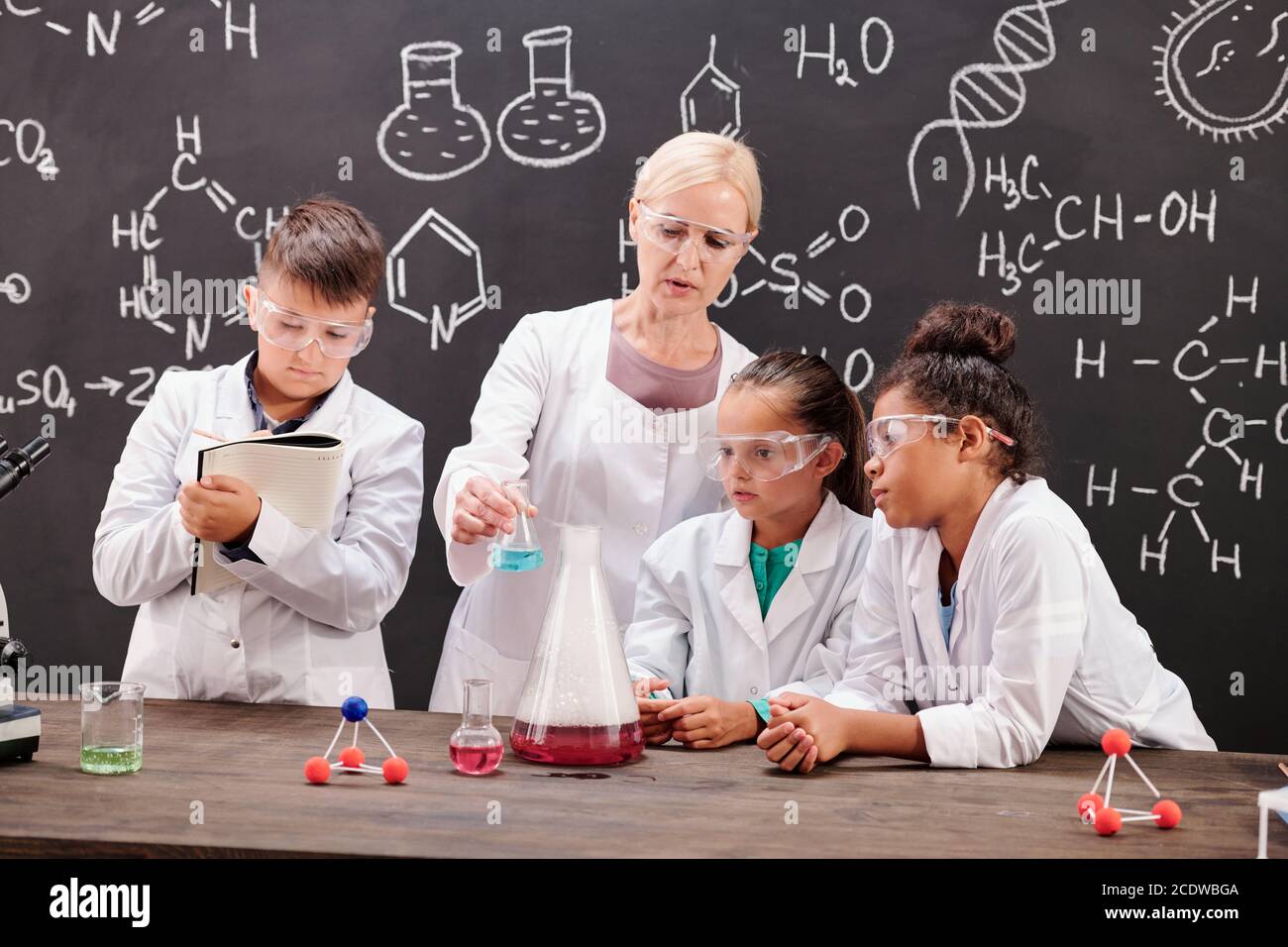 Group of clever students of secondary school during chemical experiment ...