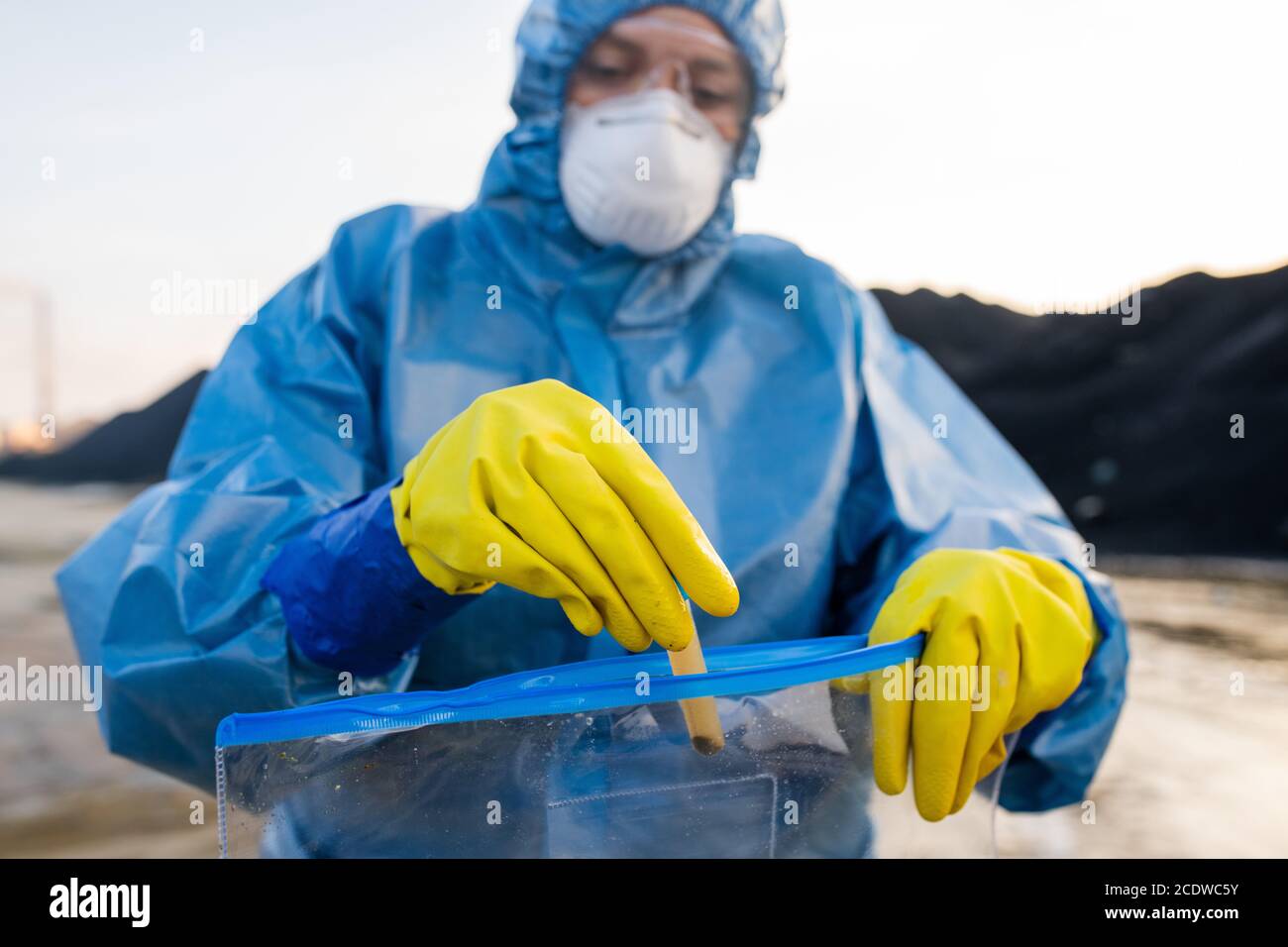 Ecologist putting flask with sample of water from dangerous area into ...