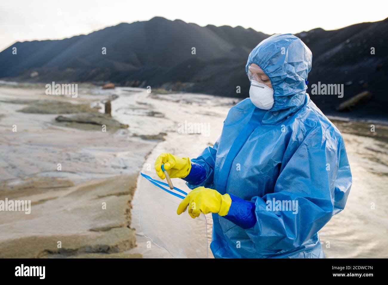 Contemporary researcher putting flask with sample of dirty water into ...