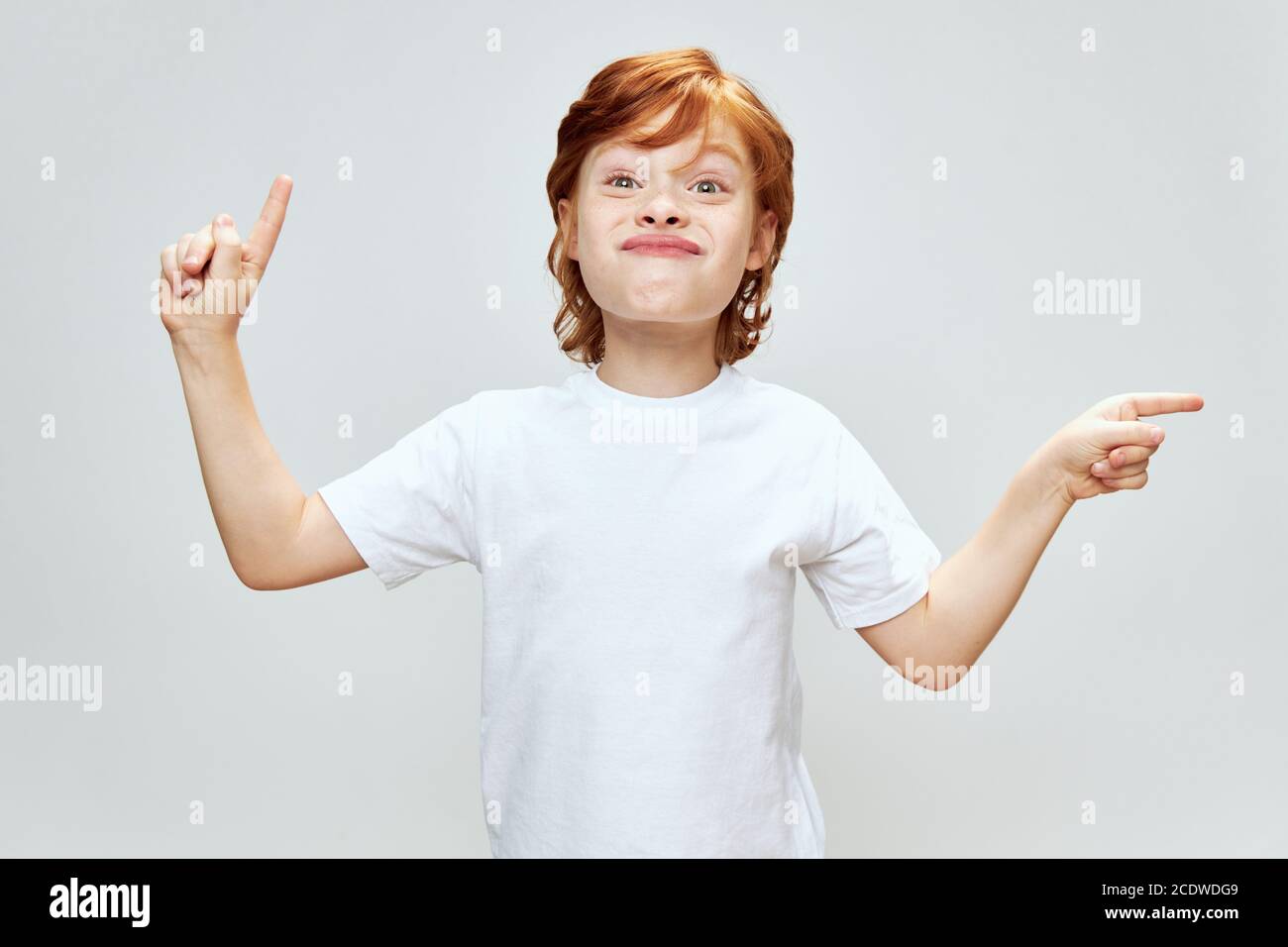 red-haired boy with a stupid expression on his face gestures with his ...