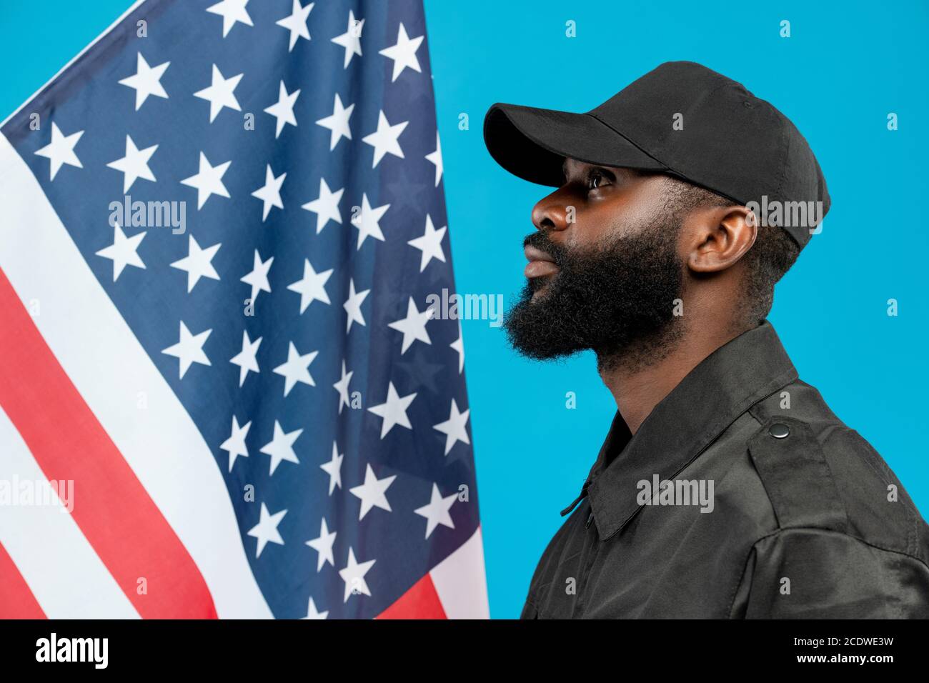 Young bearded African-american male security in black uniform and cap ...