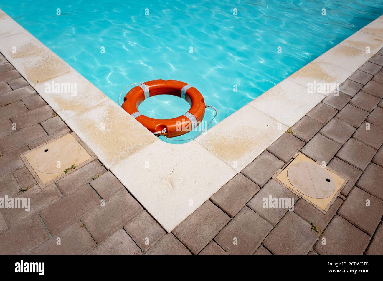 Life preserver floating in a clear pool water Stock Photo - Alamy