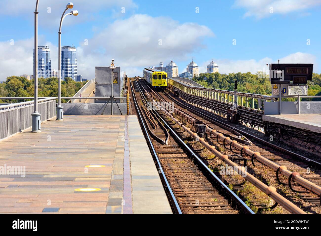 The metro train rushes through the metro bridge in Kyiv to the left ...