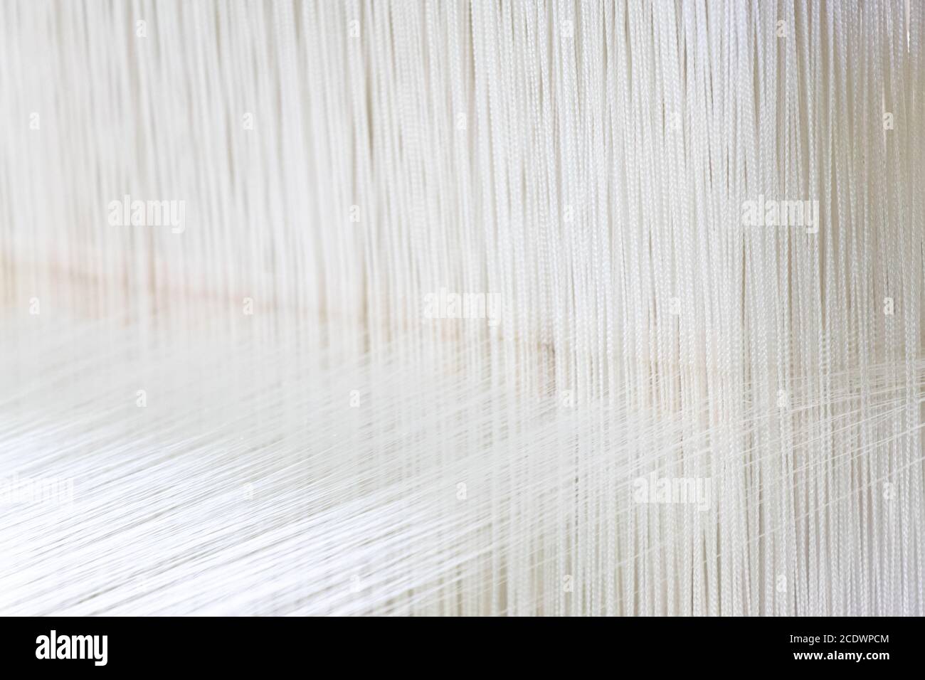 Closed up of loom with white thread background Stock Photo - Alamy