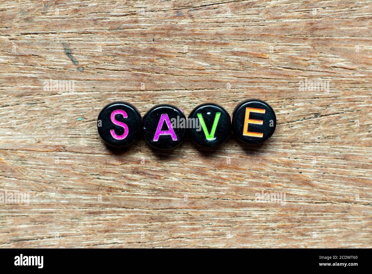Black bead with color letter in word save on wood background Stock ...