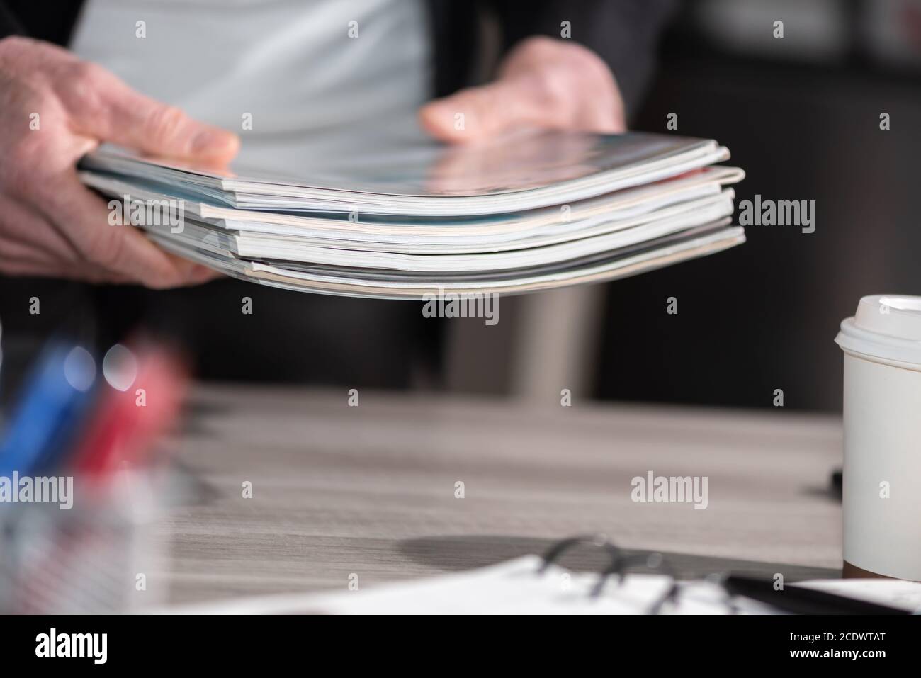 Male hands holding a stack of magazines Stock Photo - Alamy