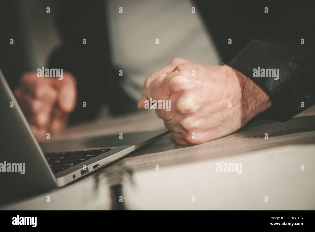 Angry businessman hitting his desk with his clenched fists Stock Photo ...