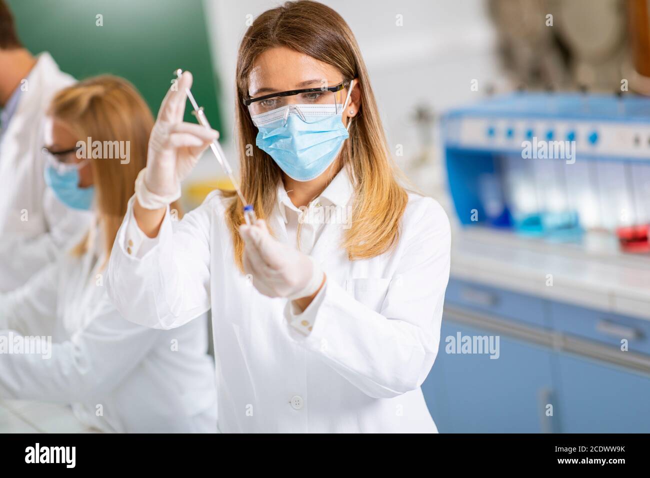 Woman doctor wearing protective face mask and safety googles in lab ...