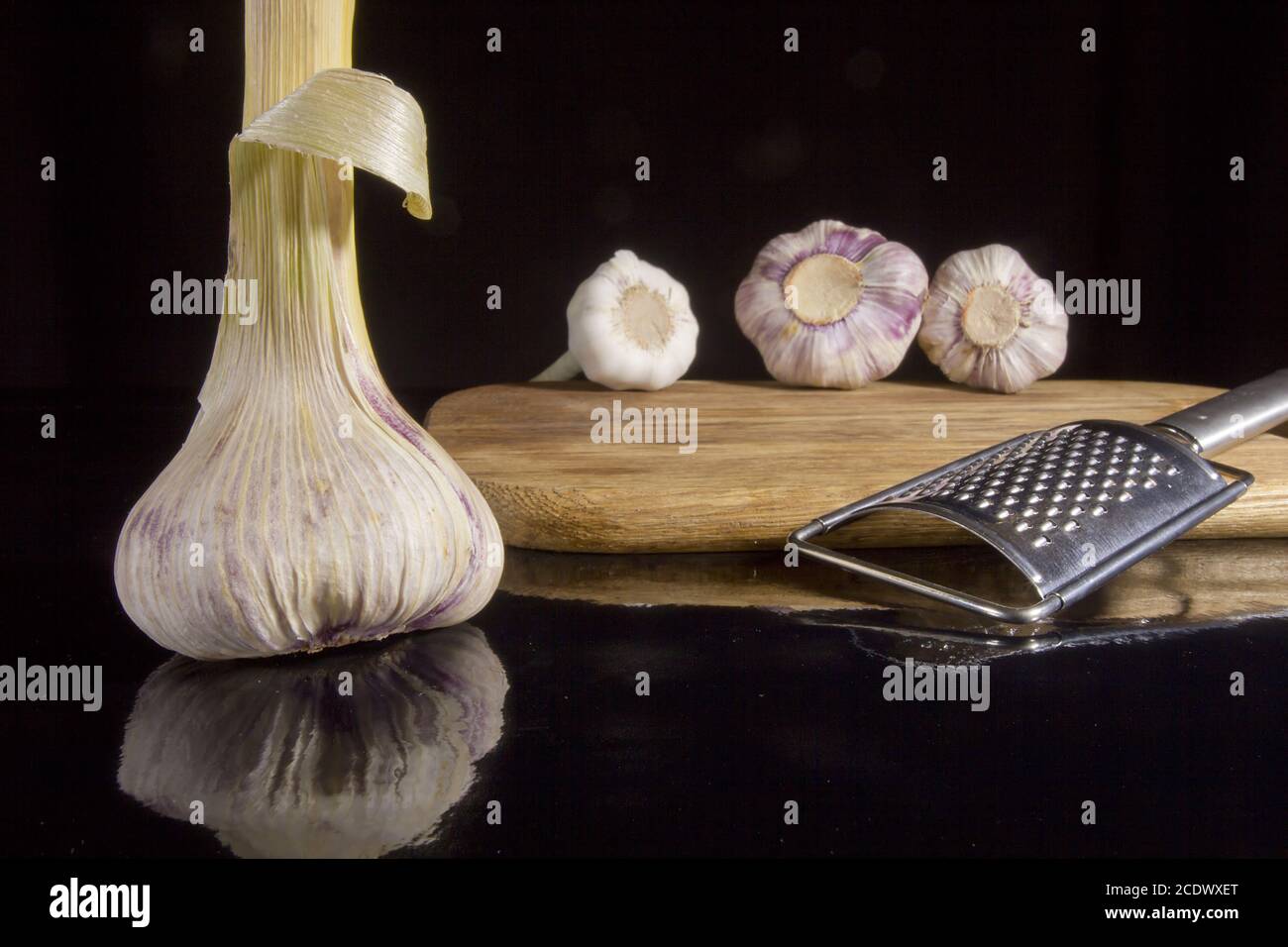 Heads of garlic and grater Stock Photo - Alamy