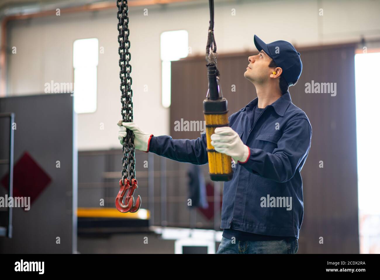 Worker operating a crane in a production facility Stock Photo - Alamy