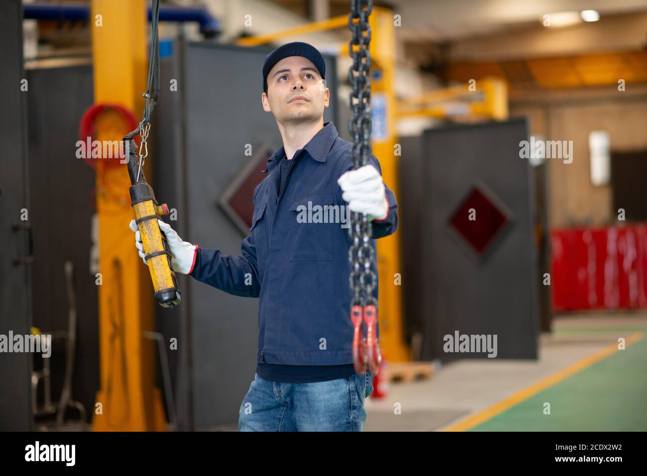 Worker operating a crane in a production facility Stock Photo - Alamy
