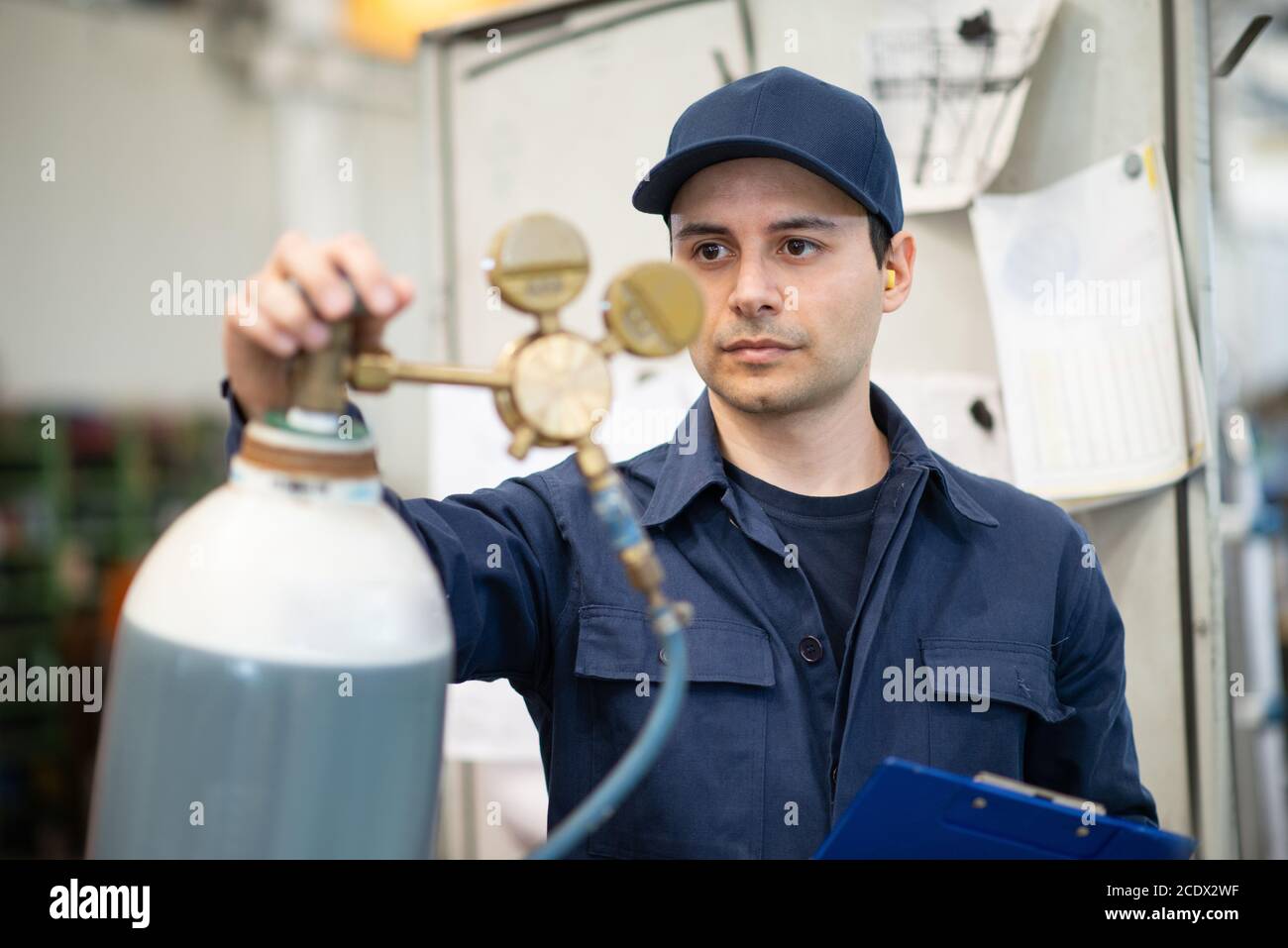 Inspector checking a gas tank in an industrial factory Stock Photo - Alamy