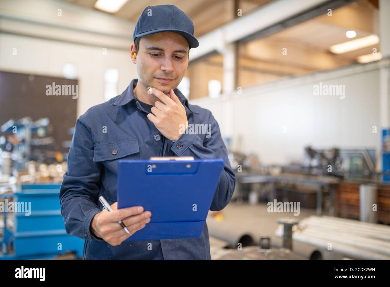 Worker reading a document in big industrial facility Stock Photo - Alamy